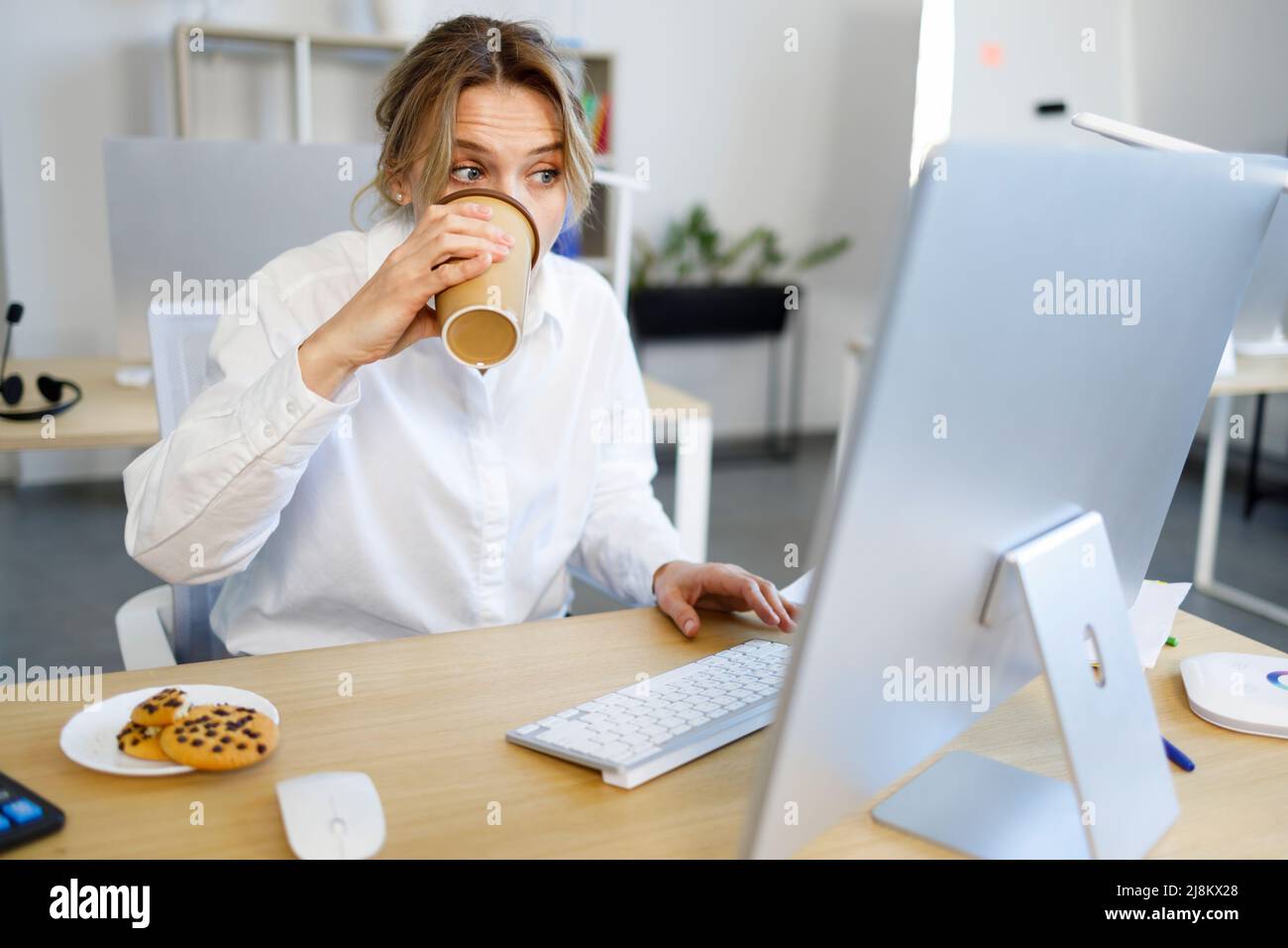 Concentrated at work business woman office worker in a hurry drinking ...