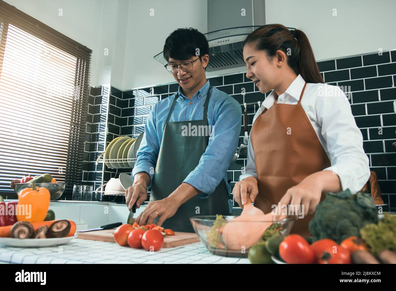Asian Couple having fun while cooking a meal in kitchen Stock Photo - Alamy