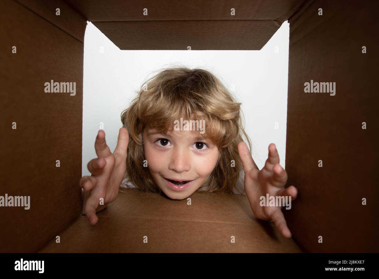 Child looking inside cardboard box, bottom view. Delivering your ...