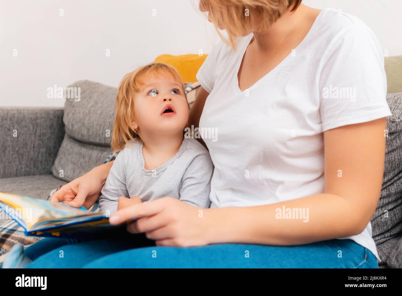 A woman is engaged in reading with a small autistic child ...