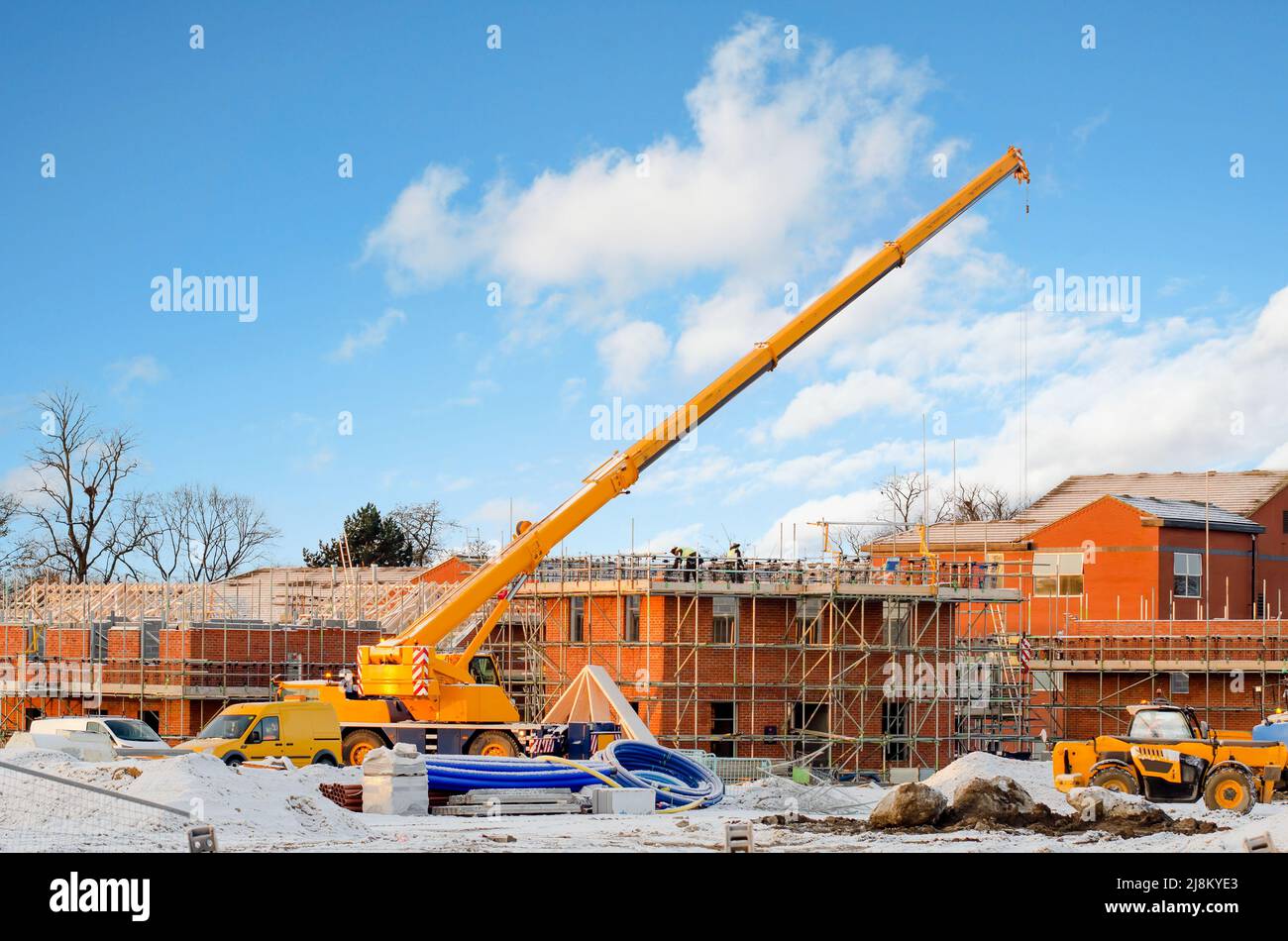 Mobile crane on housing site in wintertime ready for lift during ...