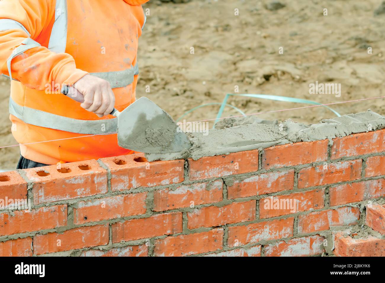 Bricklayer laying bricks on mortar on new residential house ...