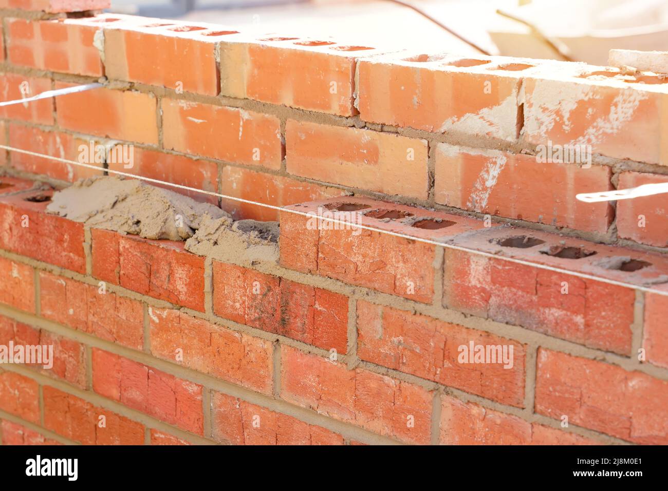 Bricklayer laying bricks on mortar on new residential house ...