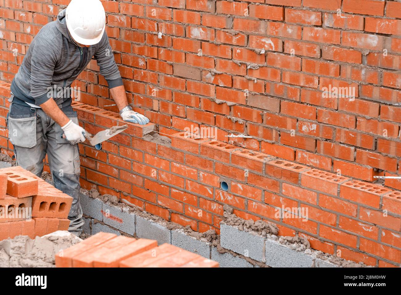 Bricklayer laying bricks on mortar on new residential house ...