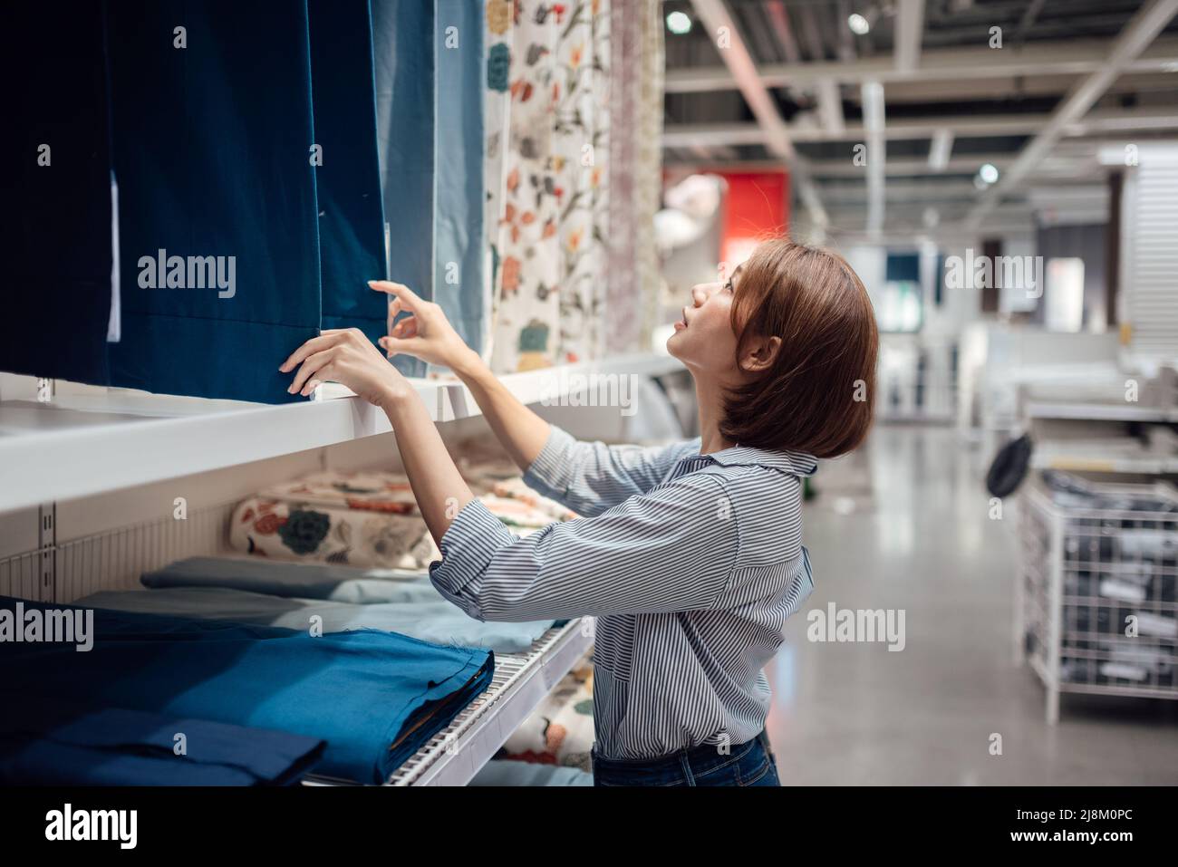 An Asian woman is selecting fabric and textile at the mall Stock Photo ...