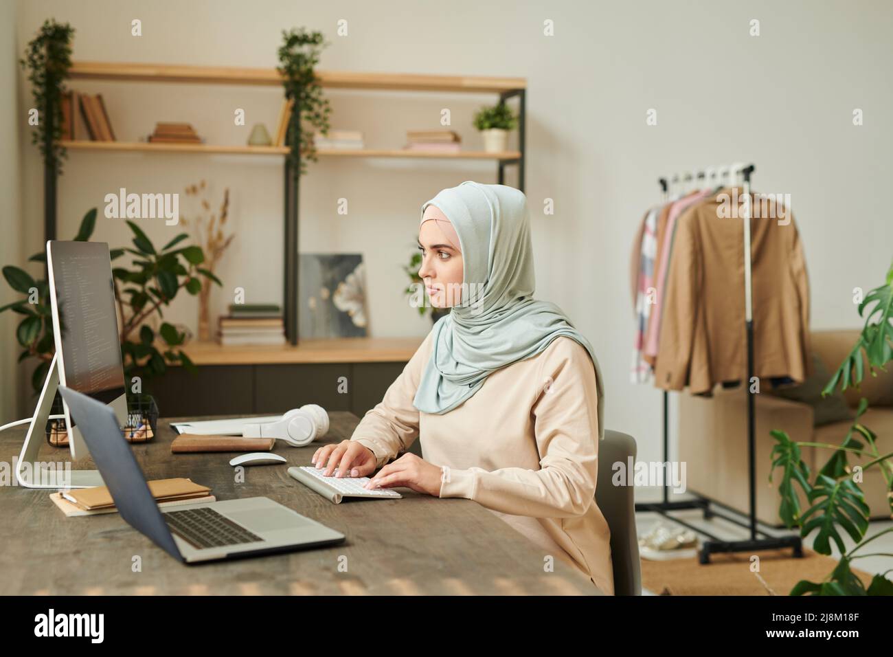 Serious young Muslim professional programmer wearing light blue hijab ...
