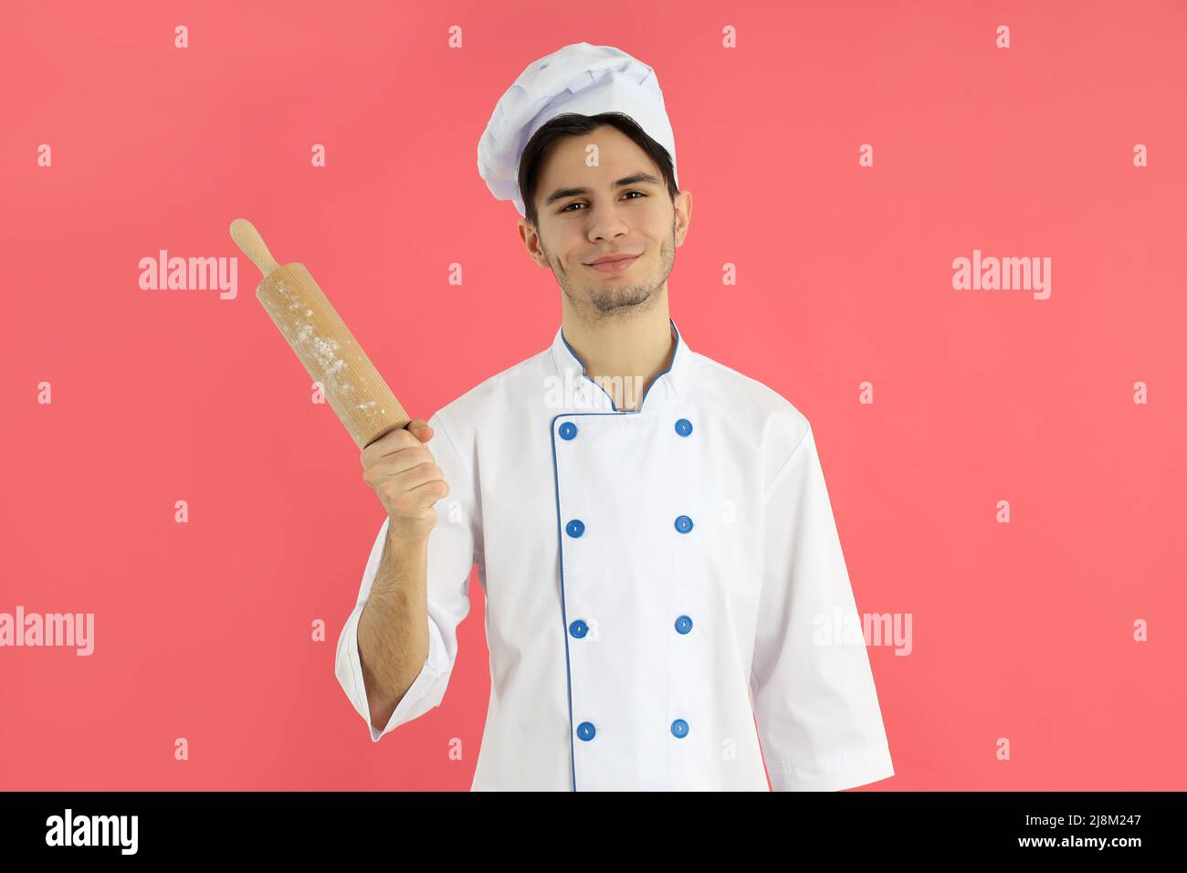 Concept of cooking, young man chef on pink background Stock Photo - Alamy