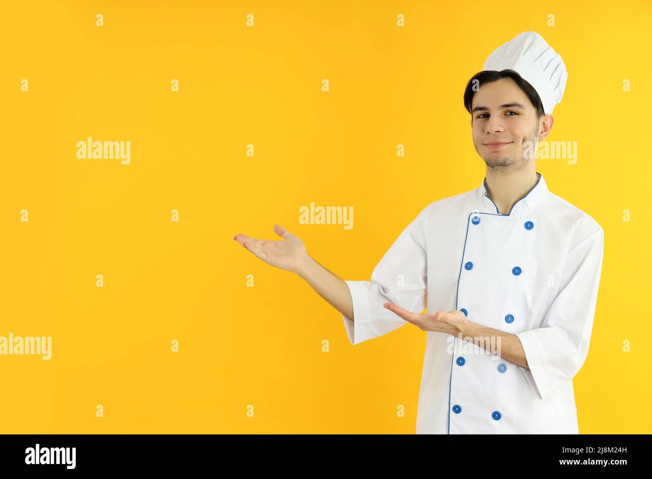 Concept of cooking, young man chef on yellow background Stock Photo - Alamy