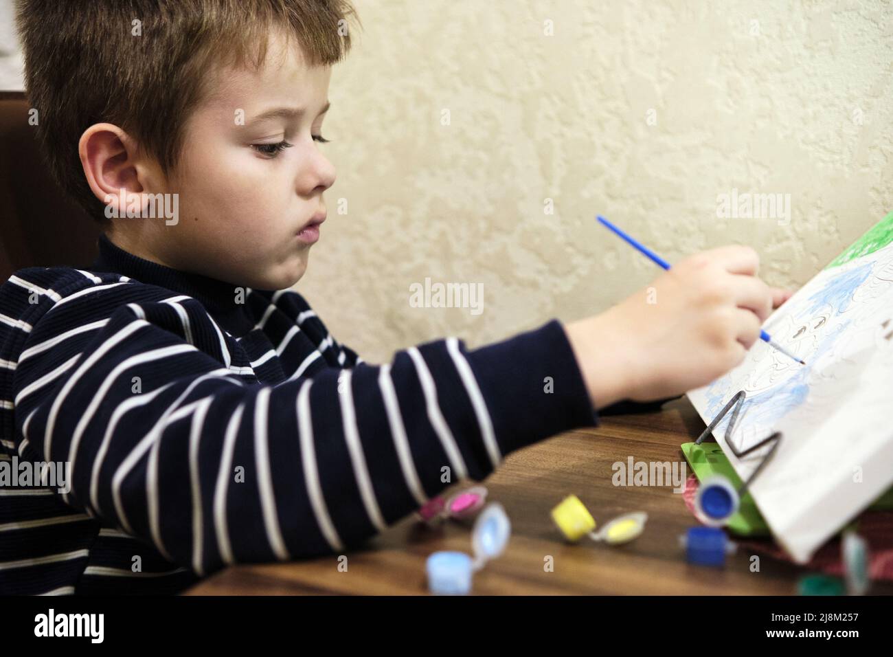 Little boy draws a brush and paint his first picture Stock Photo - Alamy