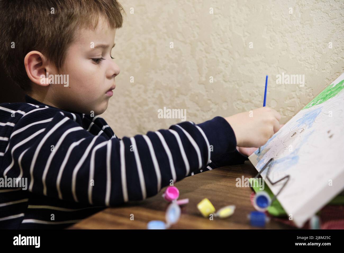 Little boy draws a brush and paint his first picture Stock Photo - Alamy