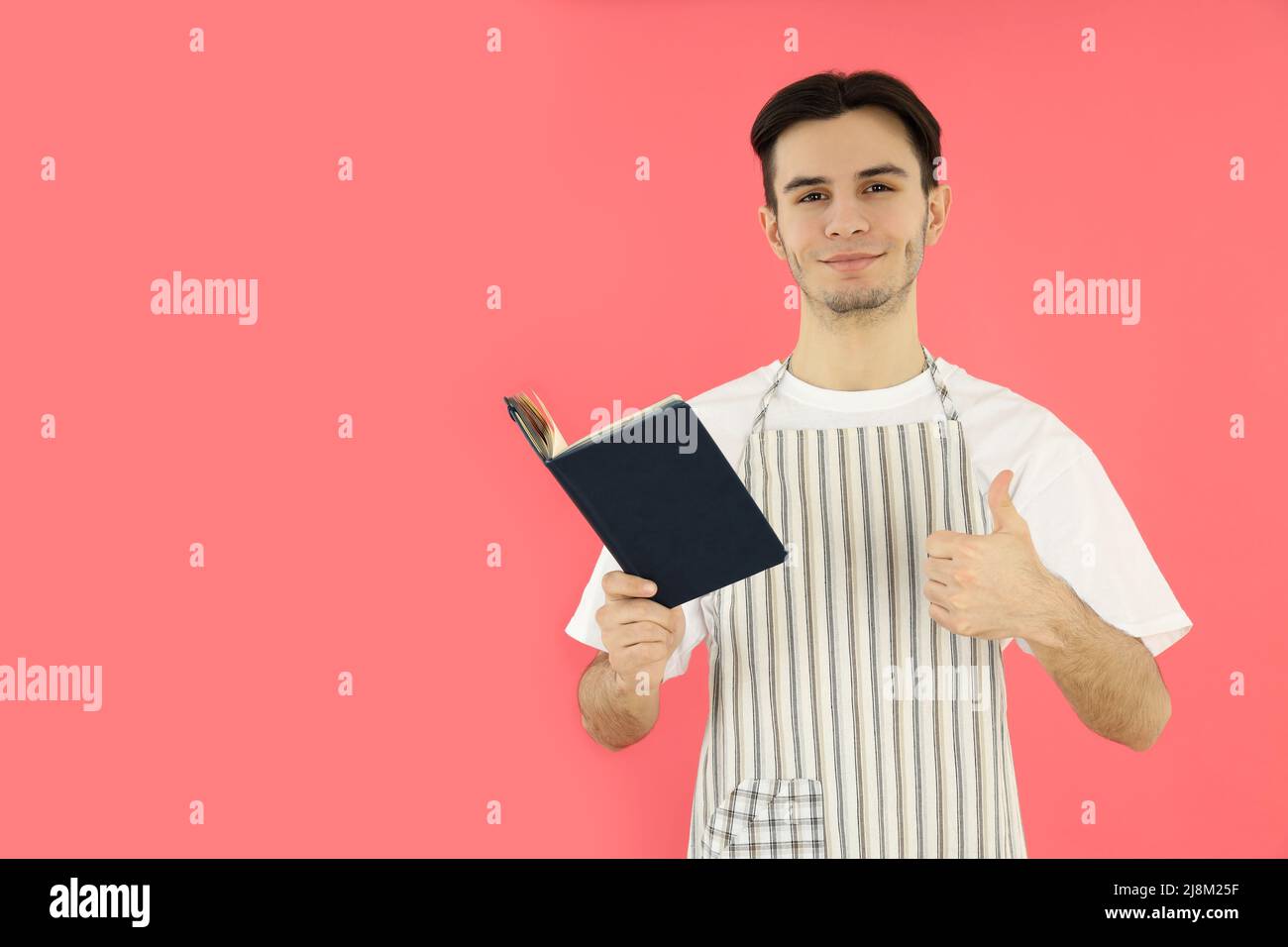 Concept of cooking, young man chef on pink background Stock Photo - Alamy