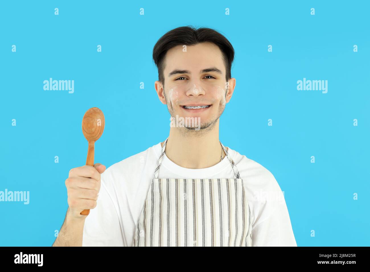 Concept of cooking, young man chef on blue background Stock Photo - Alamy