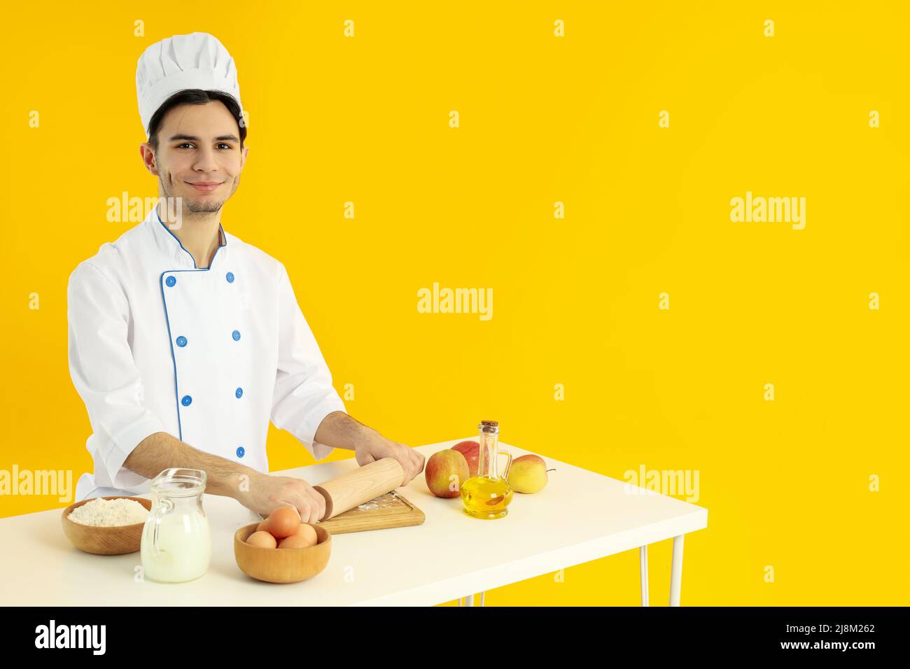 Concept of cooking, young man chef on yellow background Stock Photo - Alamy