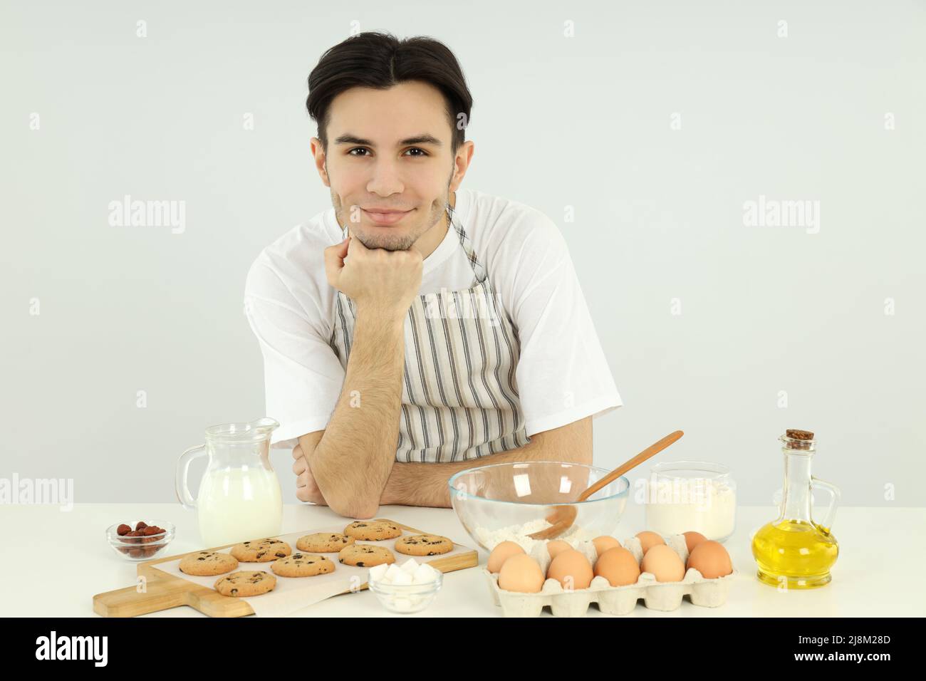 Concept of cooking, young man chef on light background Stock Photo - Alamy