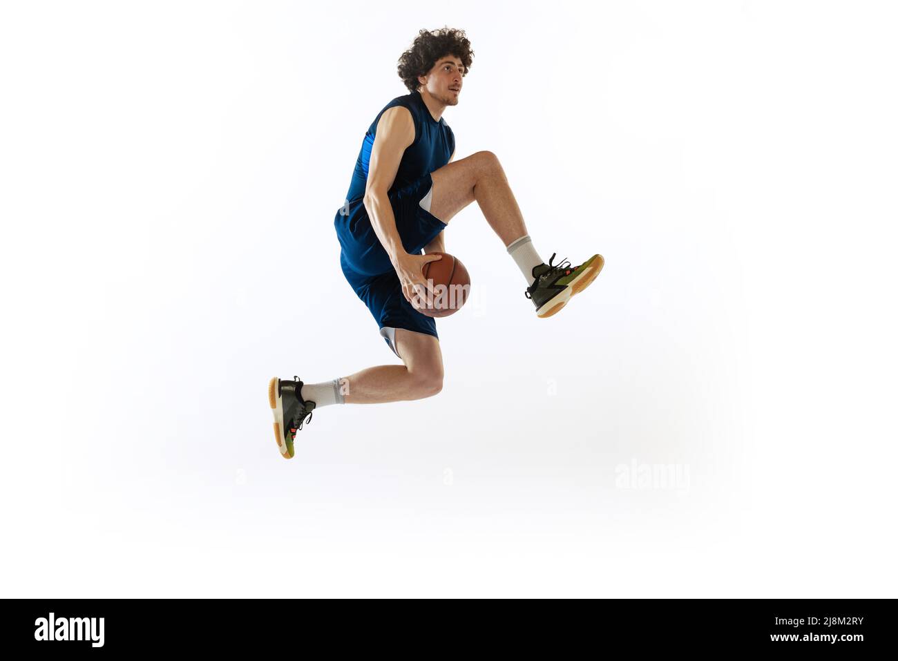 Dynamic portrait of young man, basketball player playing basketball ...