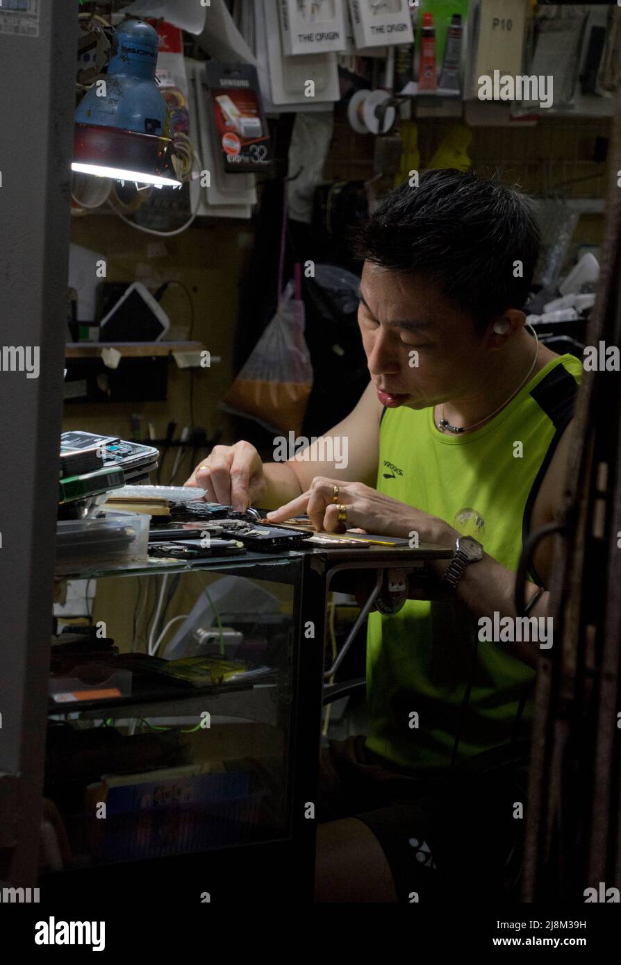 Man fixing mobile phones in a shop in the streets of George Town,Penang ...