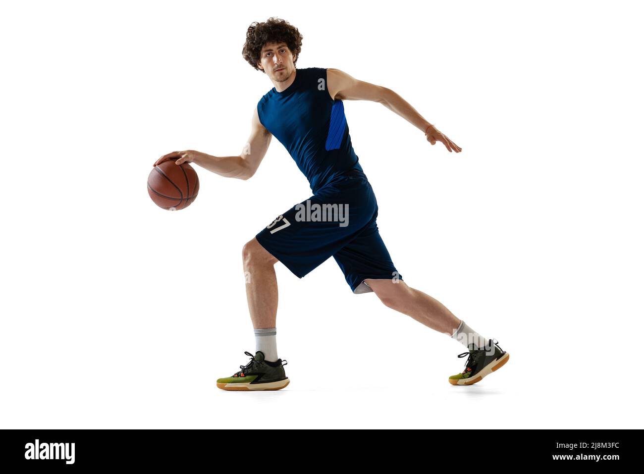 Dynamic portrait of young man, basketball player playing basketball ...