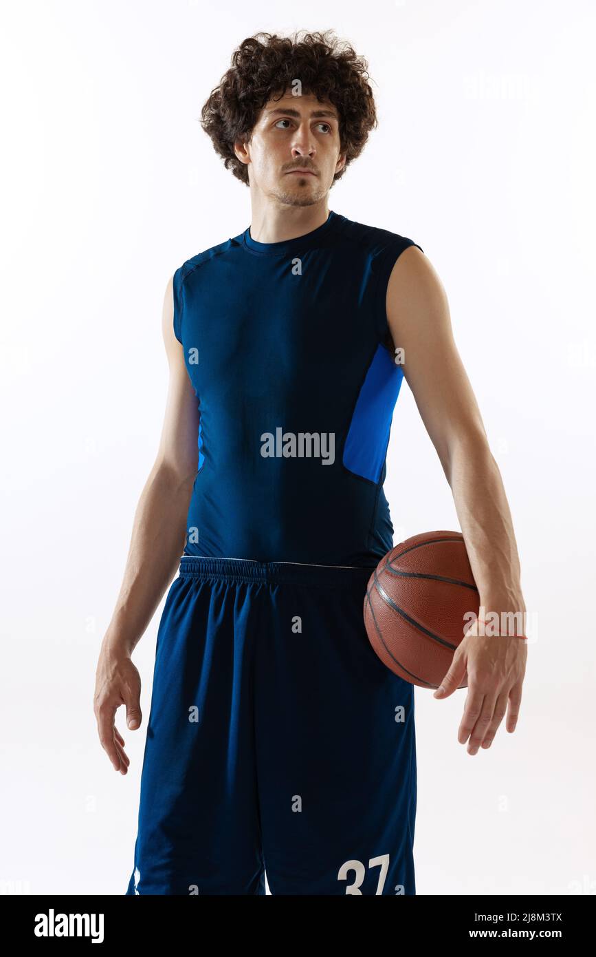 Portrait of young muscular basketball player posing isolated on white ...