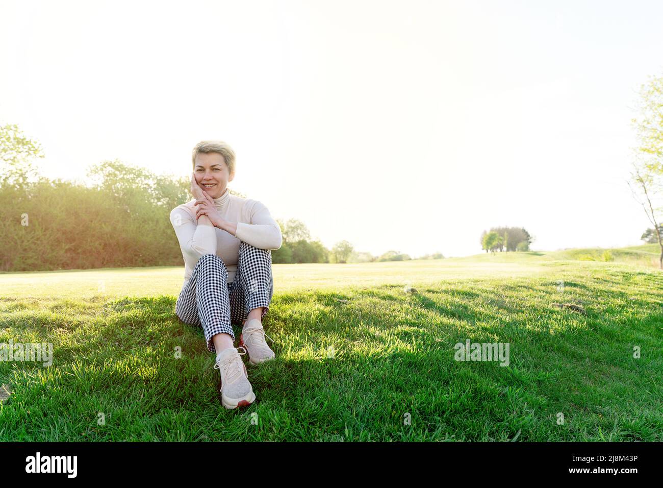 a woman meditating on a lawn on a warm sunny spring day Stock Photo - Alamy