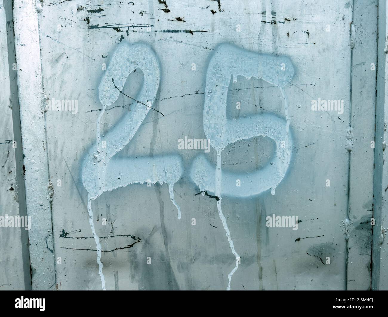 Number twenty five on metallic surface written with white spray paint ...