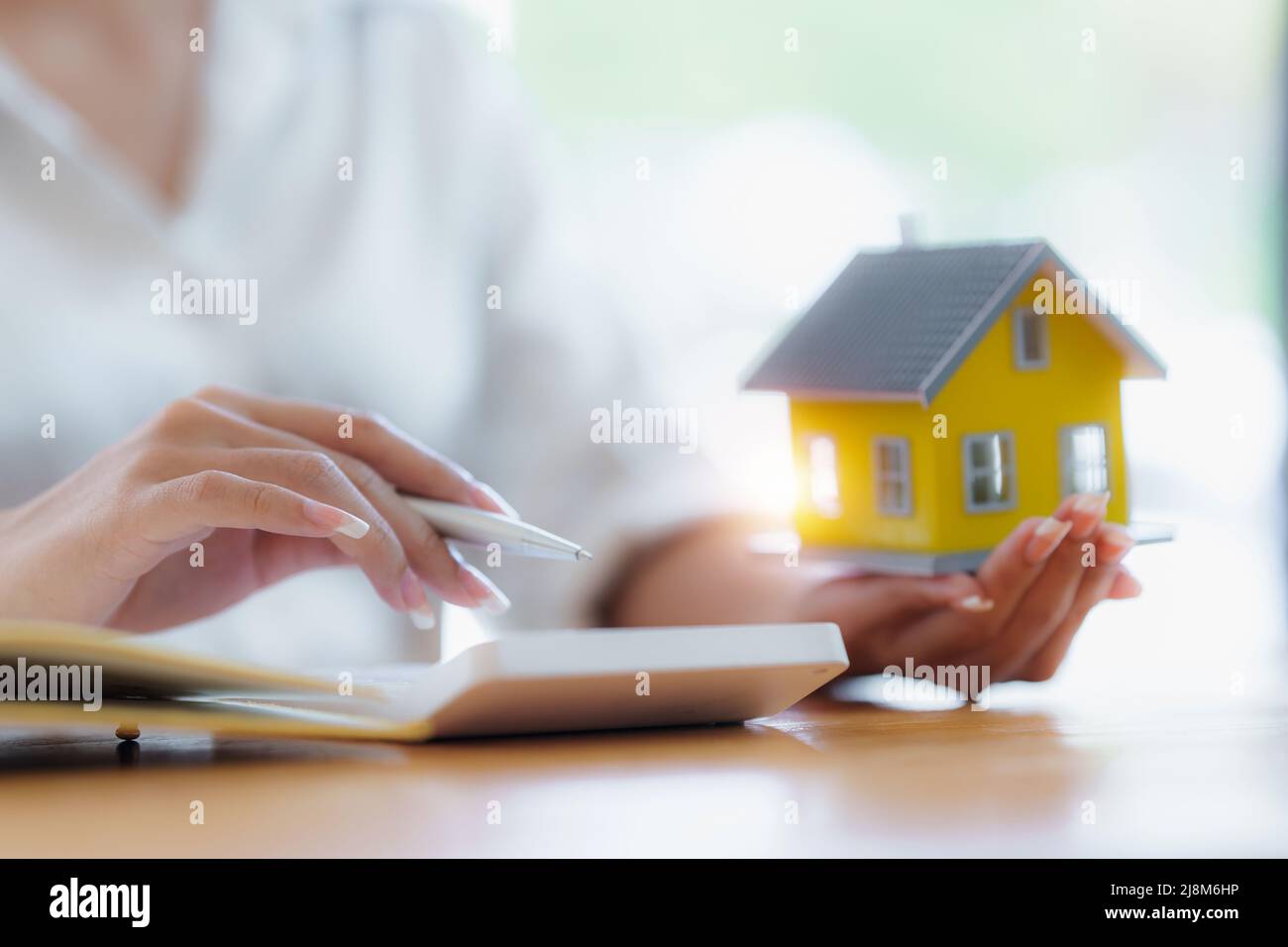 A woman holding and checking house model .Real Estate House Appraisal ...