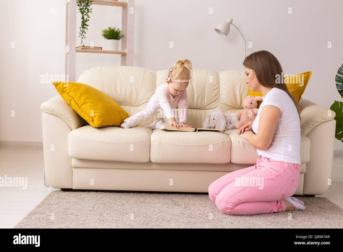 Child girl with cochlear implant with her mother at home. Hear ...