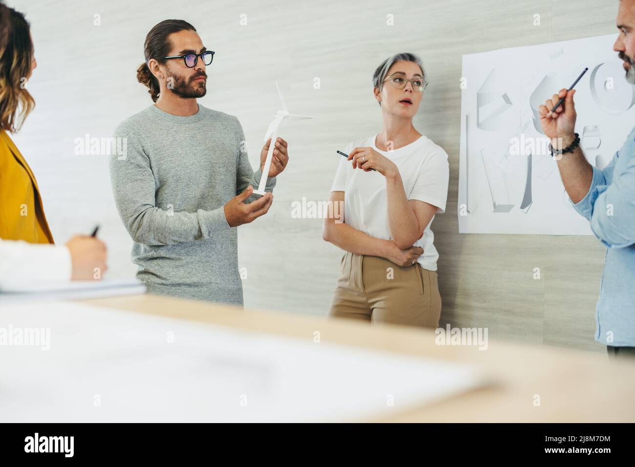 Creative design professionals having a discussion while working with ...