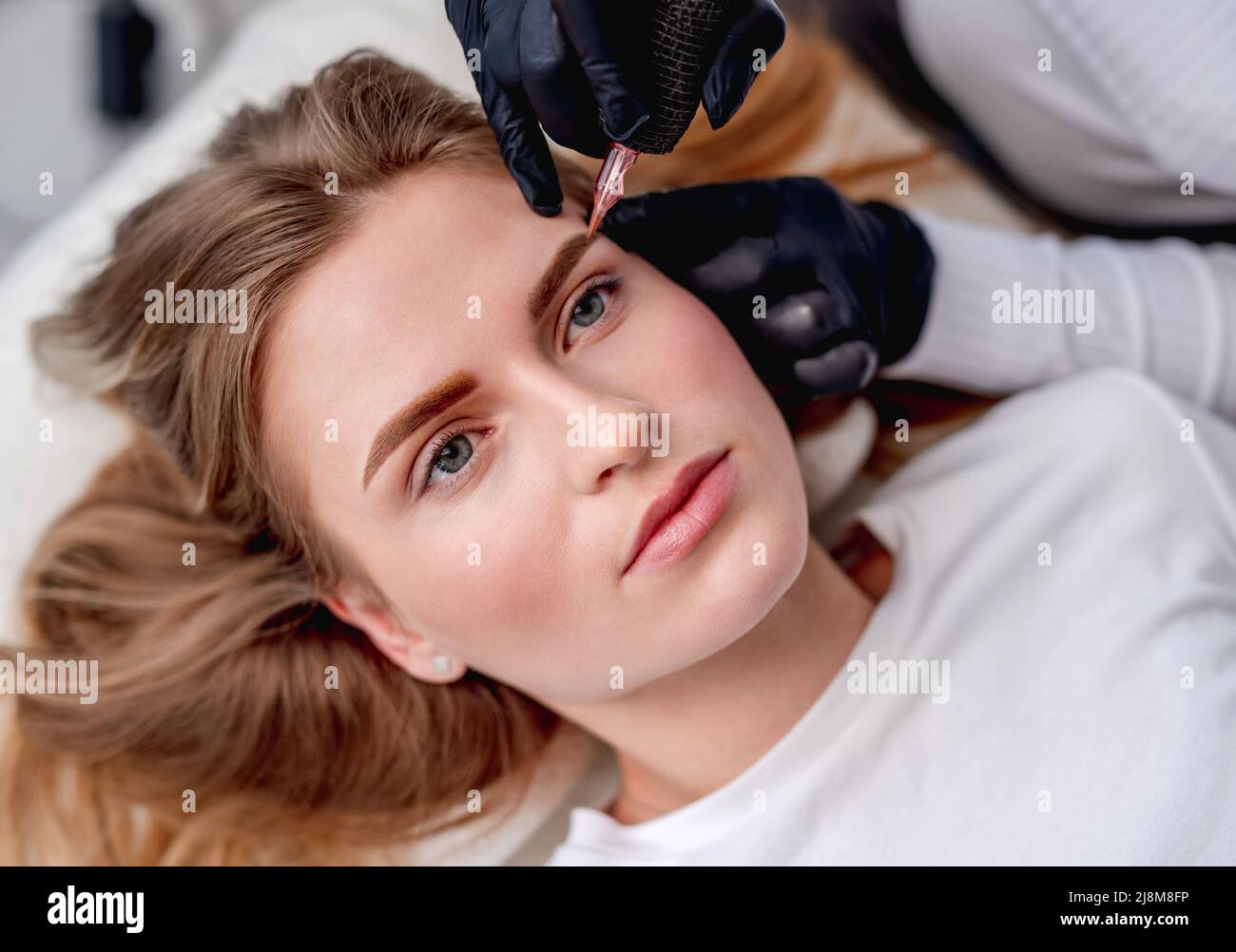 Master making eyebrows permanent makeup Stock Photo - Alamy