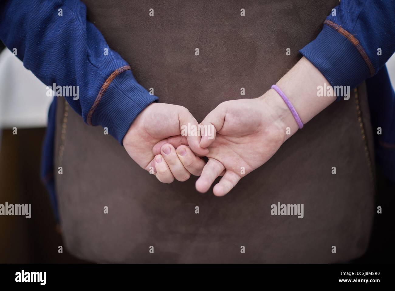Working man's arms crossed behind his back Stock Photo - Alamy