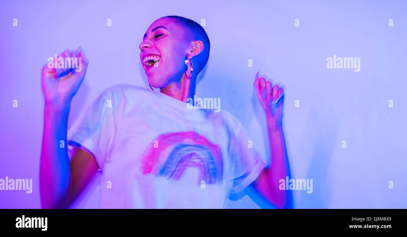 Carefree young woman dancing joyfully while standing alone in bright ... Carefree young woman dancing joyfully while standing alone in bright ...