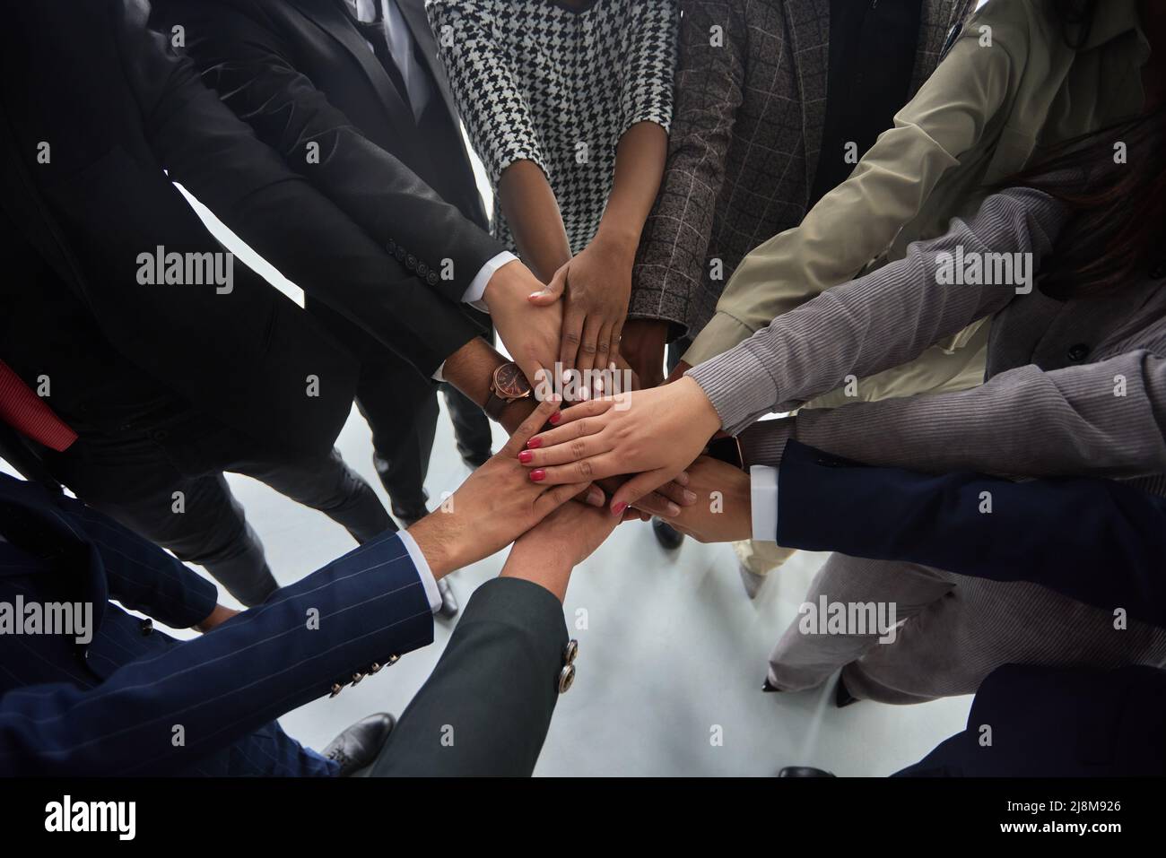 Many multiracial hands coming together as a team Stock Photo - Alamy