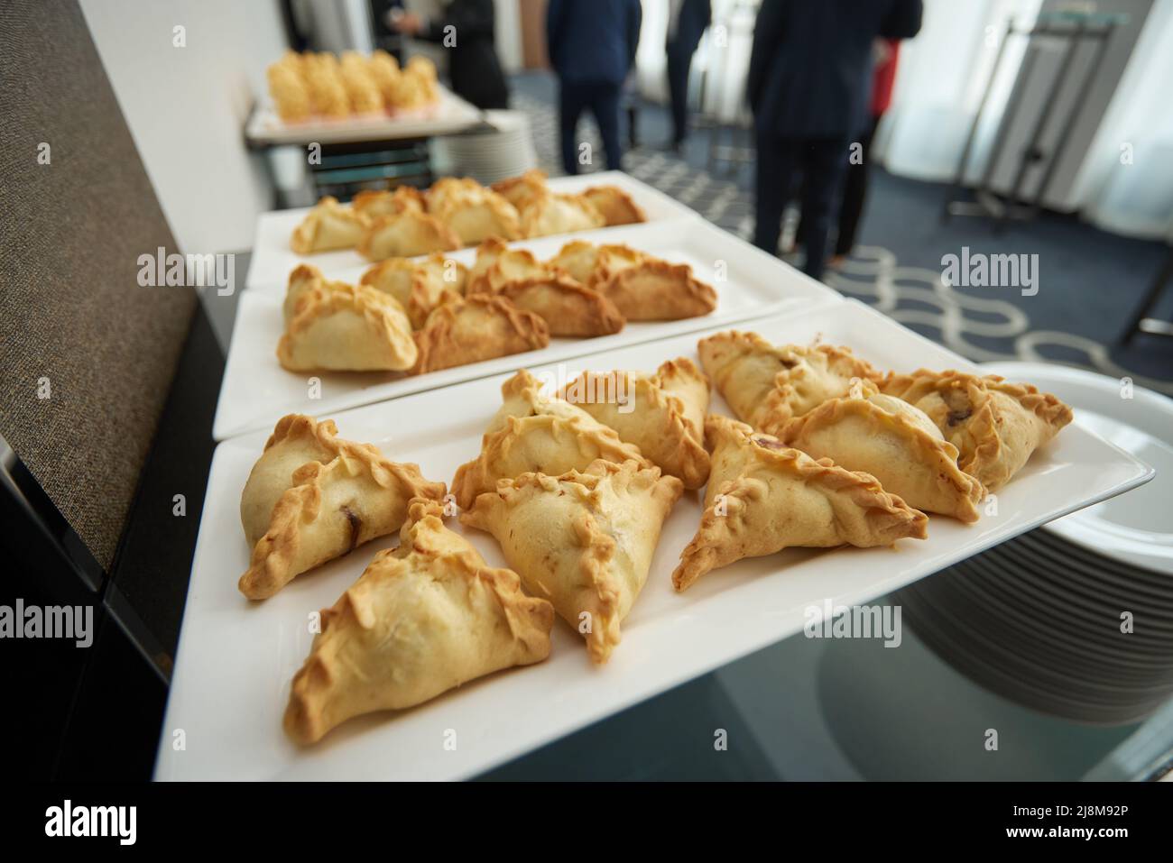 Triangular pies on a plate uchpochmak catering Stock Photo - Alamy