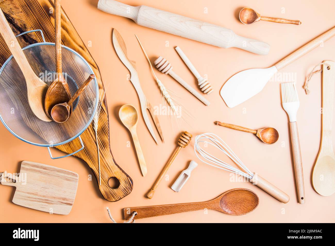 top view of various kitchen utensils laid out on a light background ...