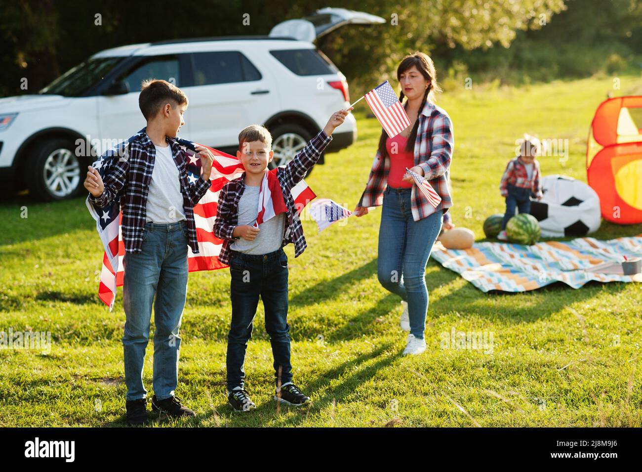 American family. Mother and four kids. With USA flags. America ...