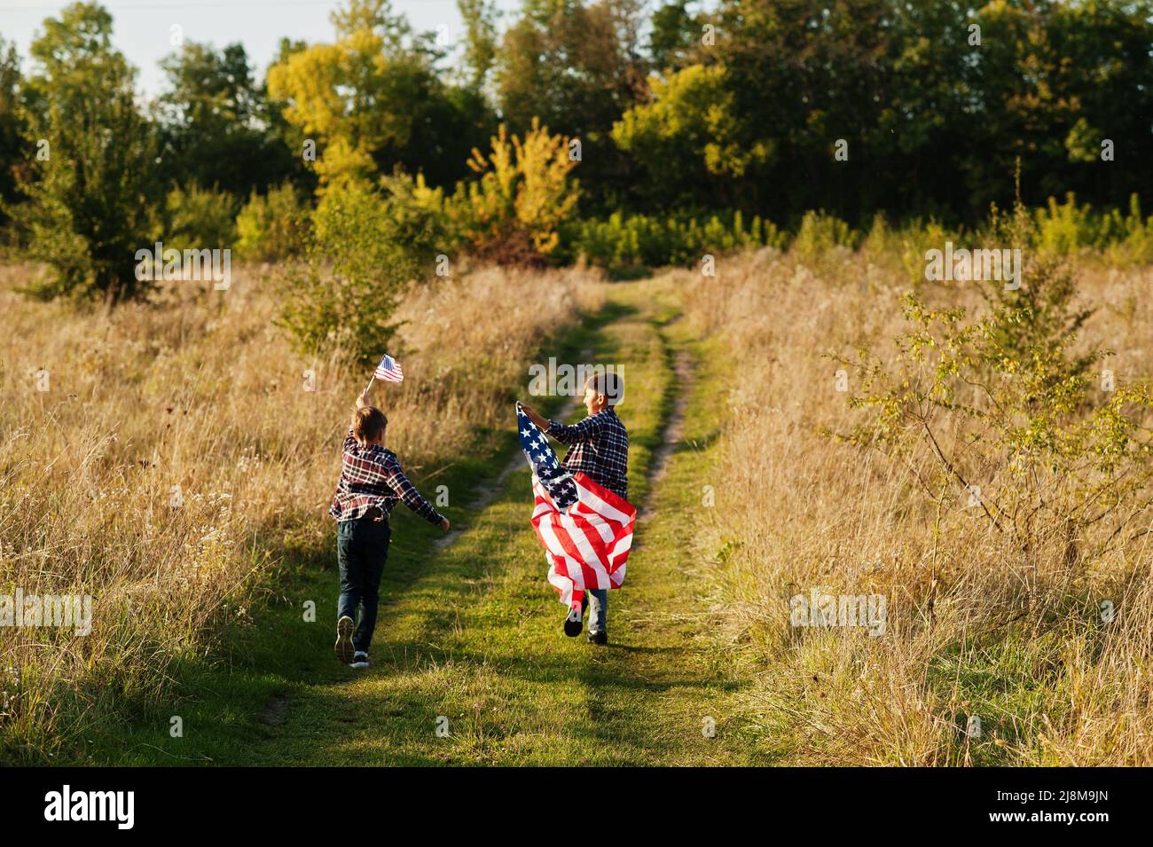 Two brothers running with USA flag. America holiday. Proud to be ...