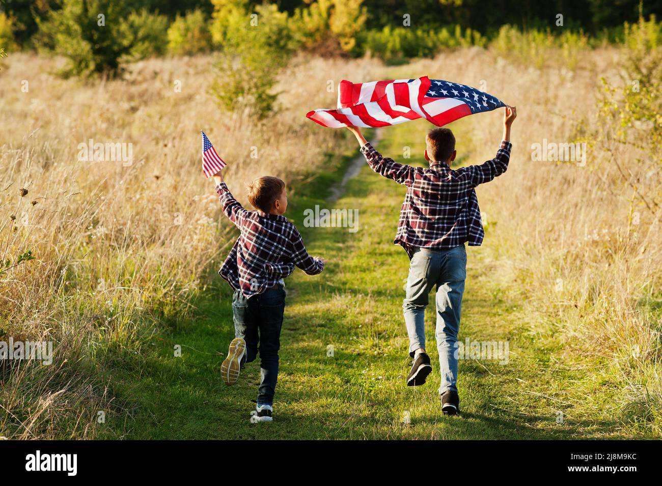 Two brothers running with USA flag. America holiday. Proud to be ...
