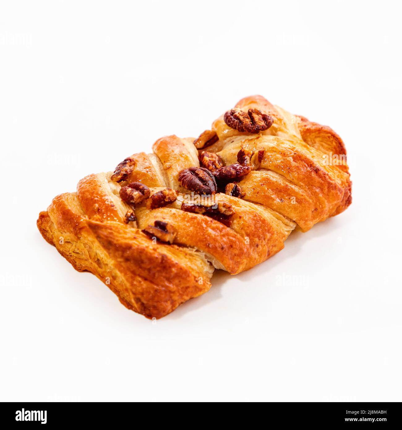 Crispy appetizing pigtail of puff pastry with pecan nuts, close-up ...