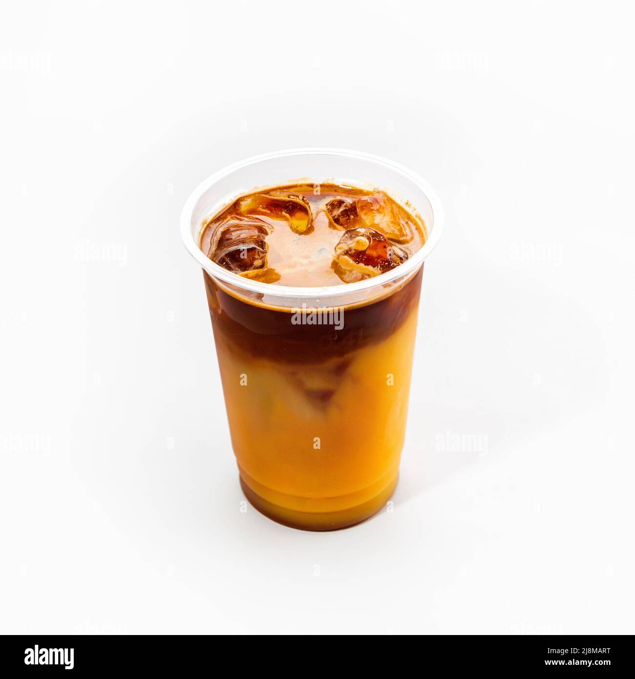 Plastic wet glass with cold coffee glace with ice cubes on a white ...