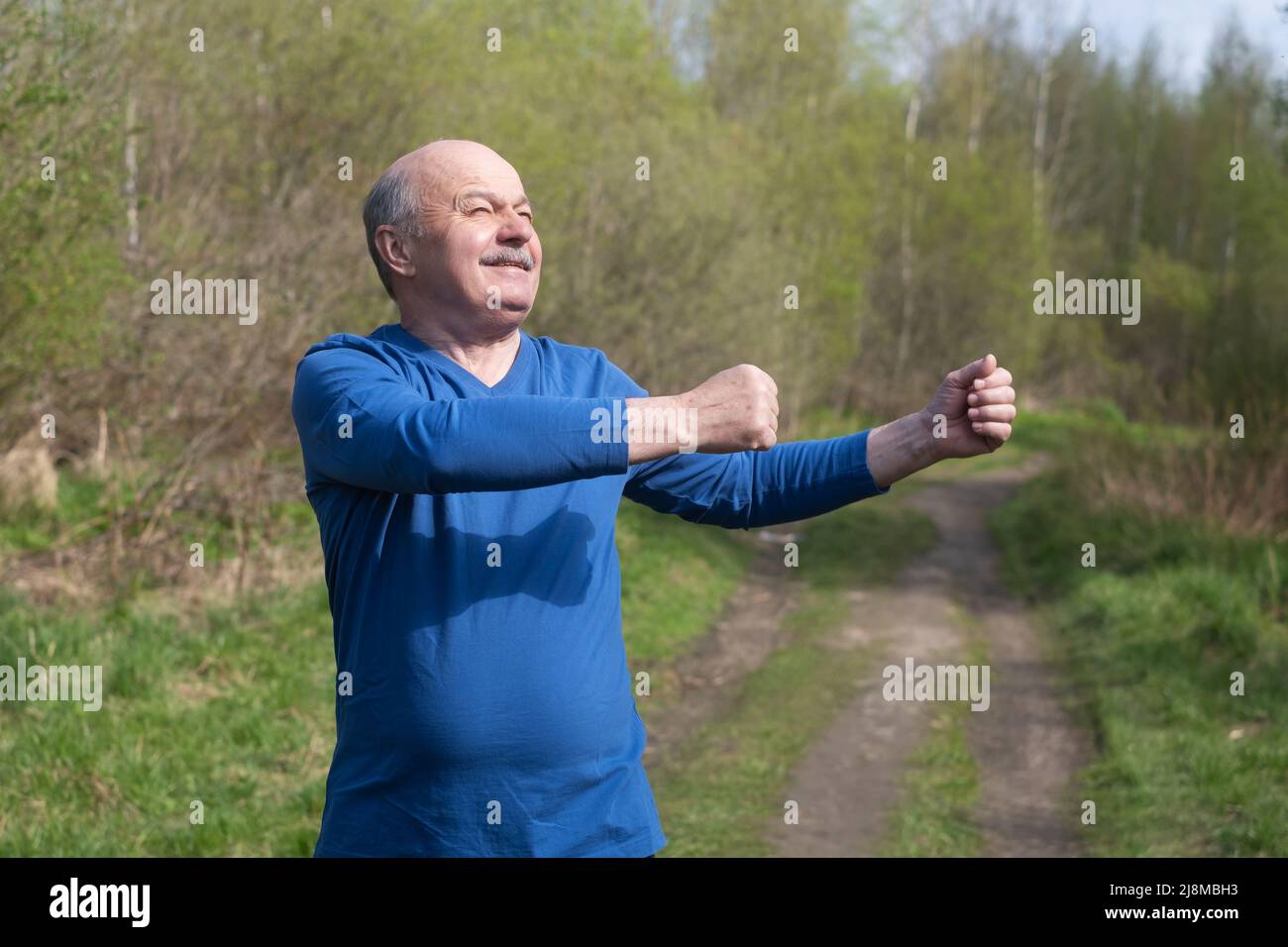 Senior runner with armband doing stretching. Spring nature. Healthy ...