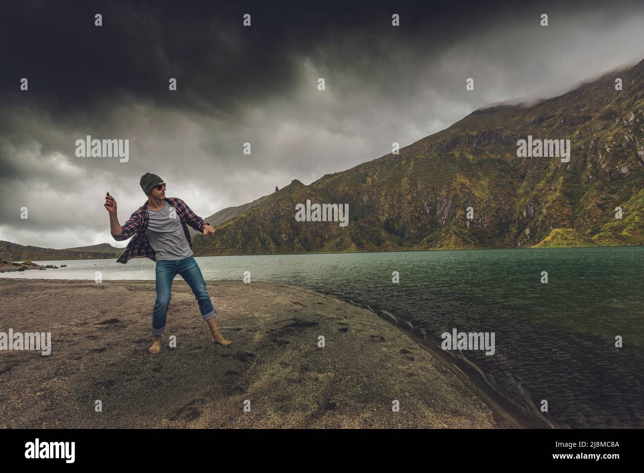 Man throwing a stone at the lake Stock Photo - Alamy