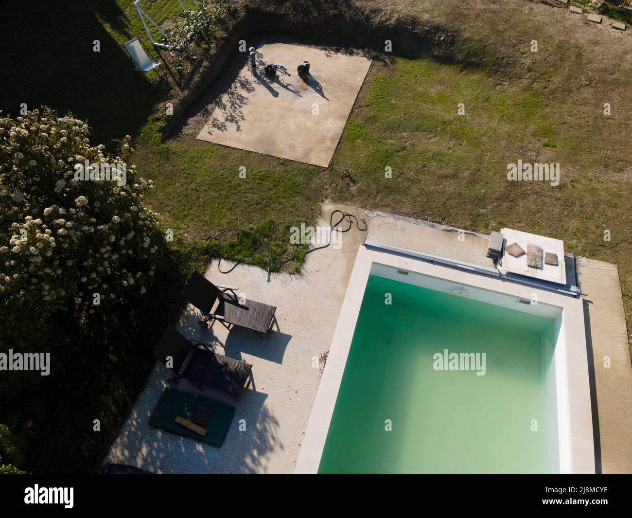 Drone flight over pool in the middle of greenery, fresh grass grown and ...