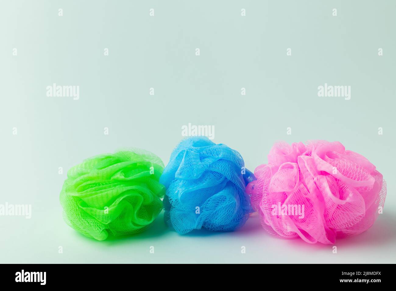 three multicolored body puffs on grey background with copy space Stock ...