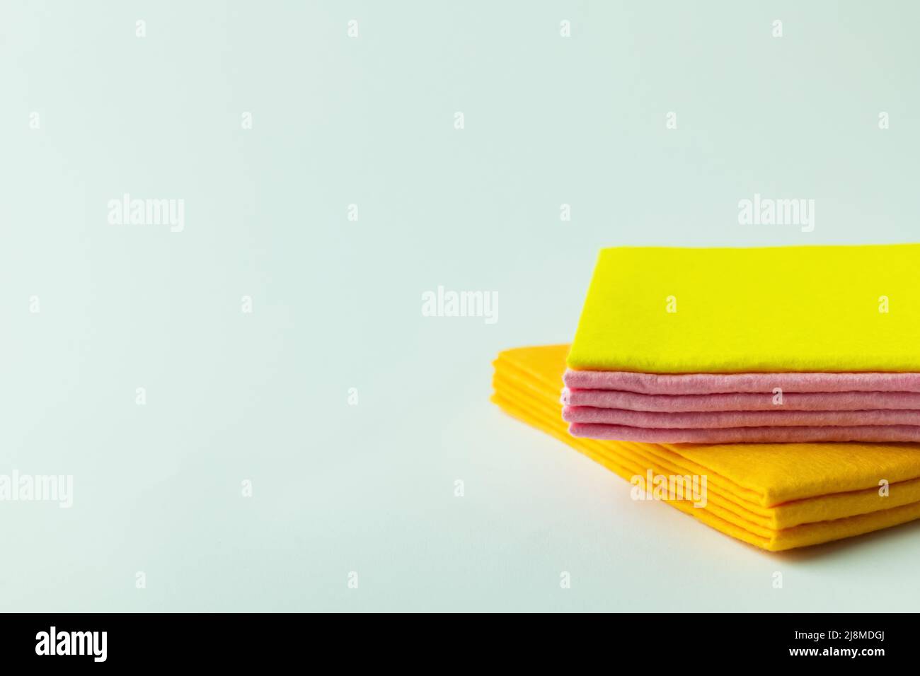 orange, yellow and pink cleansing rags on grey background with copy ...