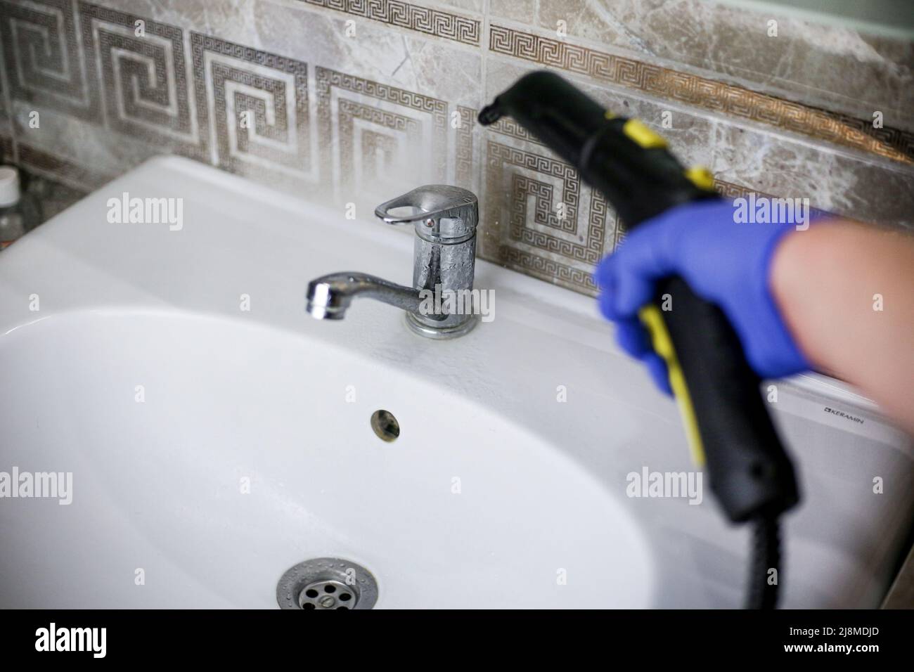 Cleaning and disinfection of the washbasin in the bathroom with hot ...