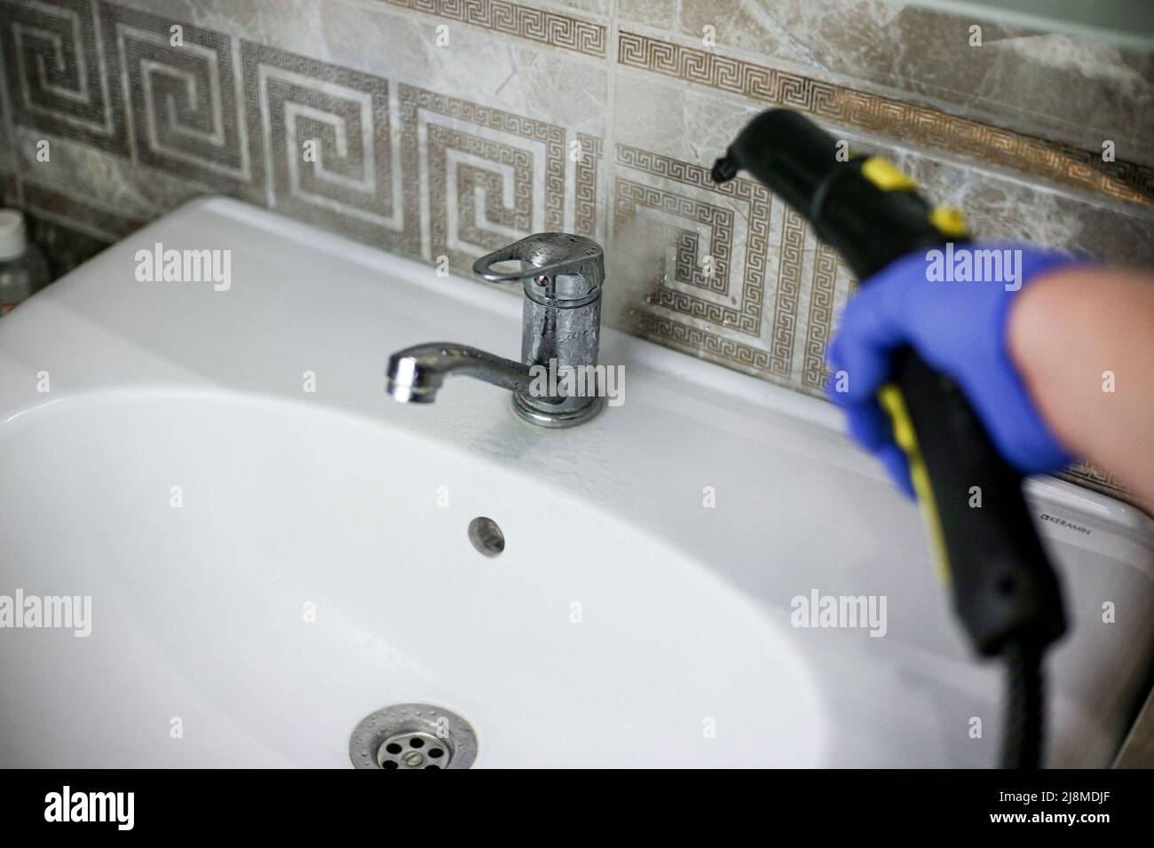 Cleaning and disinfection of the washbasin in the bathroom with hot ...