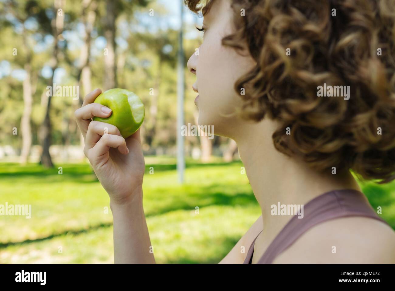 Healthy snack for fitness girl. Beautiful sporty woman eating apple ...