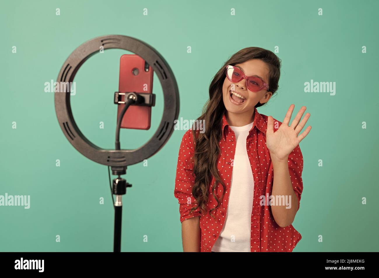 happy kid long hair waving hello on camera video blog blogging online ...