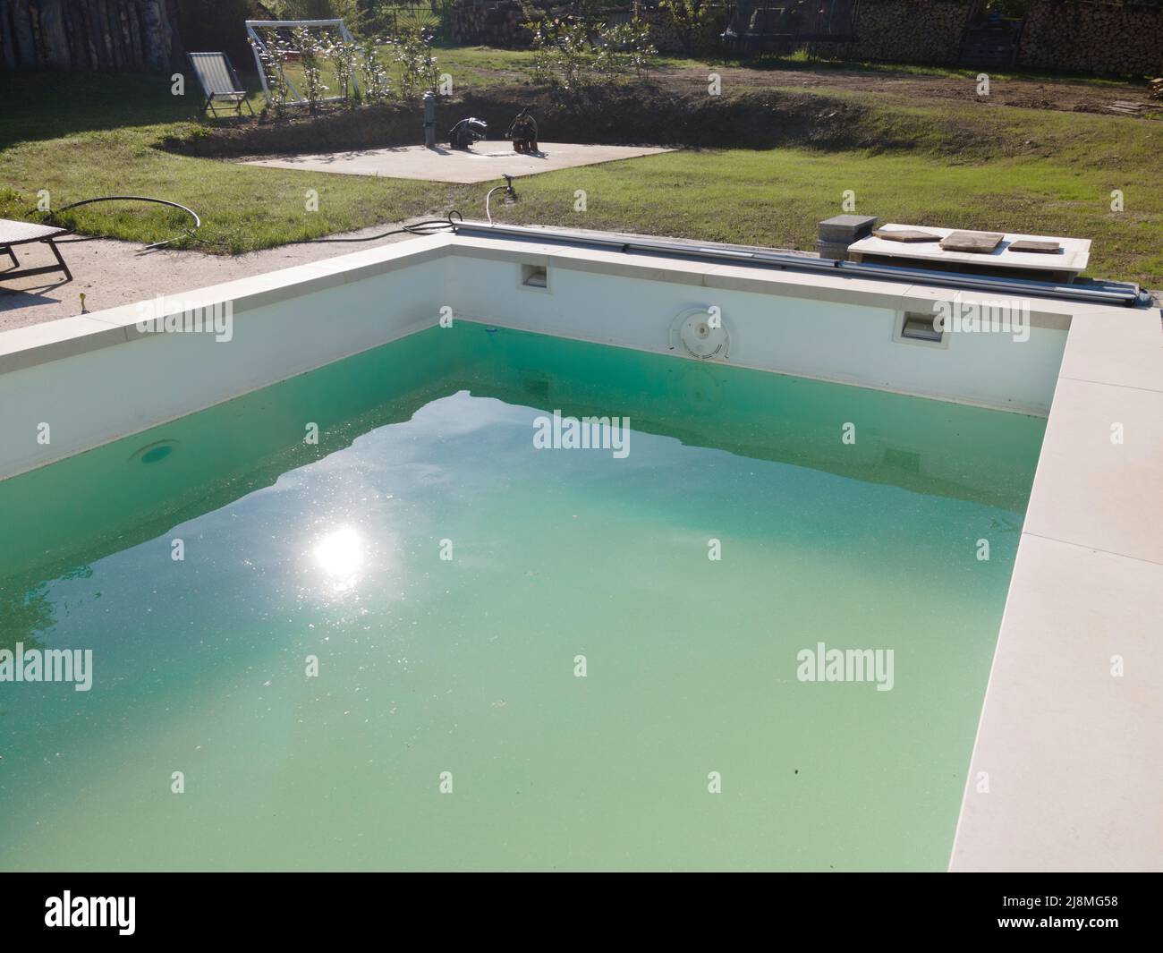 Drone flight over pool in the middle of greenery, fresh grass grown and ...