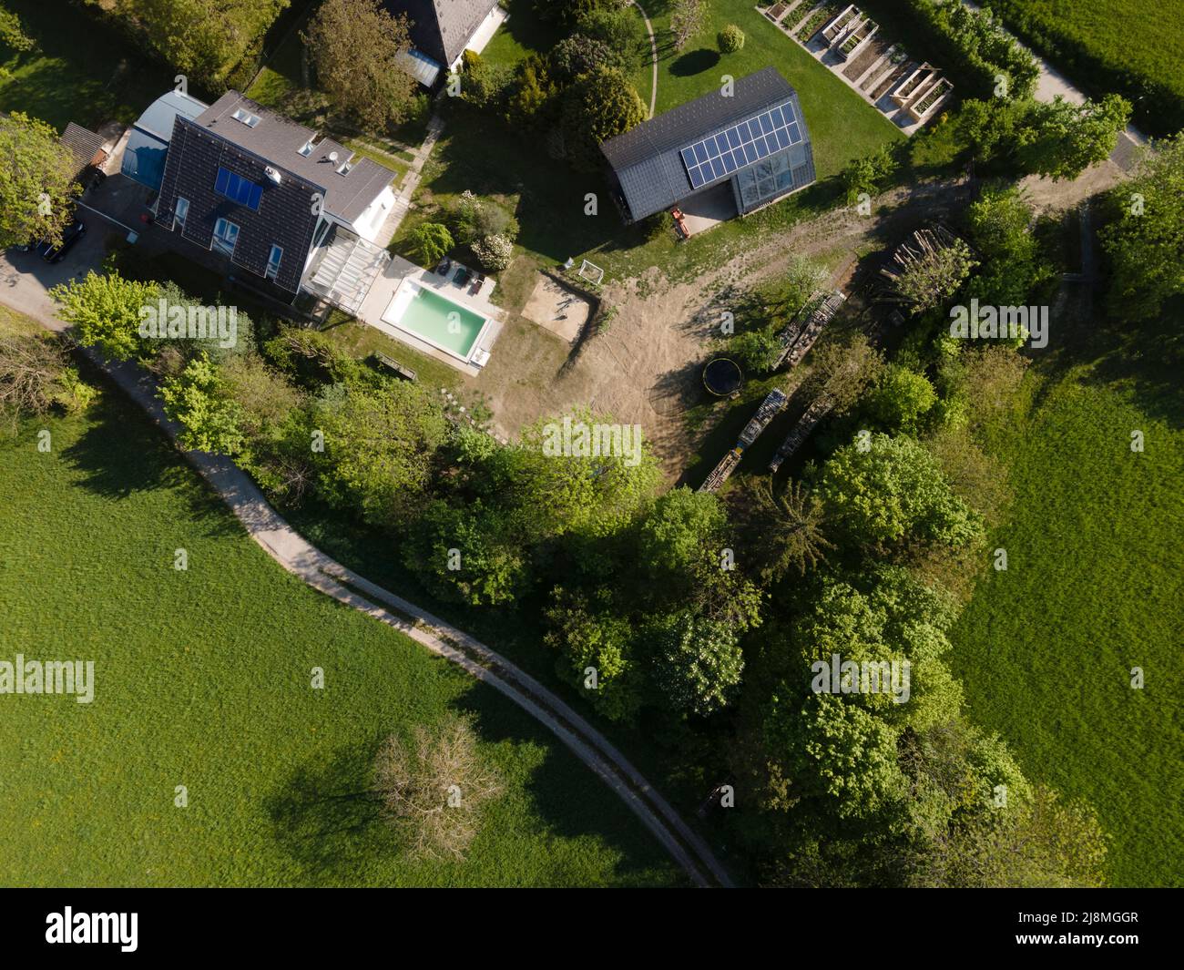 Drone flight over pool in the middle of greenery, fresh grass grown and ...