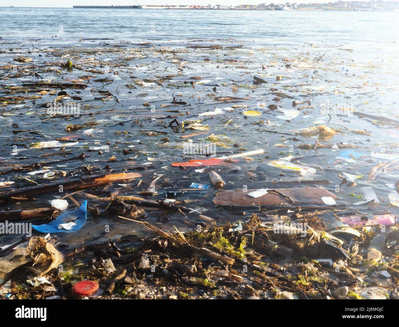 Plastic debris on blue sea surface. Polluted beach. Garbage, bottles ...
